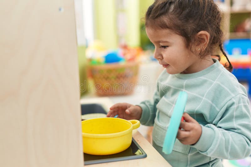 Adorable Hispanic Toddler Playing with Play Kitchen Standing at Kindergarten Stock Photo - Image ...