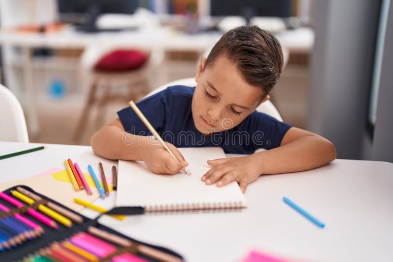 Adorable Hispanic Toddler Student Drawing on Notebook at Classroom ...