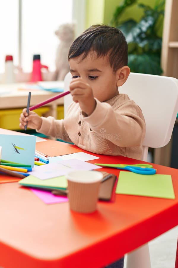 Adorable Hispanic Toddler Student Drawing on Notebook at Kindergarten ...