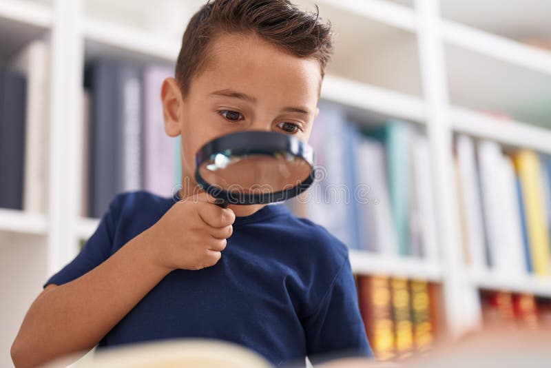 Adorable Hispanic Toddler Student Reading Book Using Magnifying Glass ...
