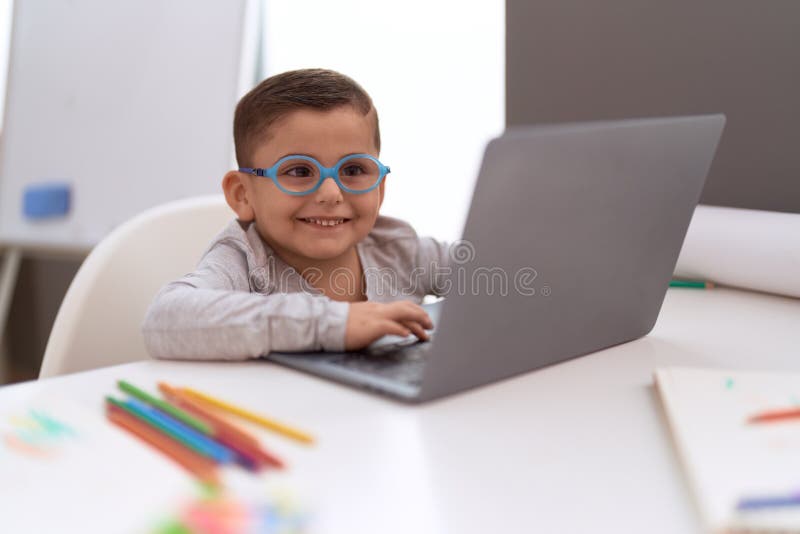 Adorable Hispanic Toddler Student Using Laptop Studying at Classroom ...