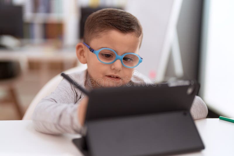 Adorable Hispanic Toddler Student Using Touchpad Studying at Classroom ...