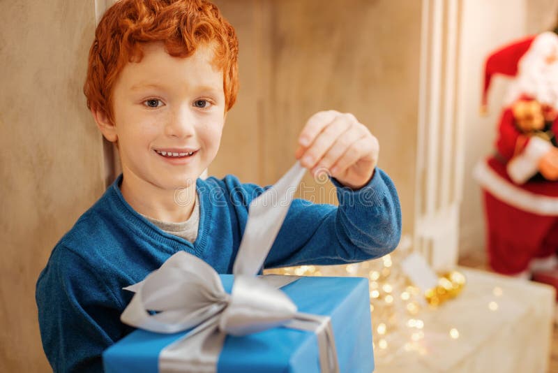 Adorable Kid Smiling into Camera while Opening His Present Stock Photo ...