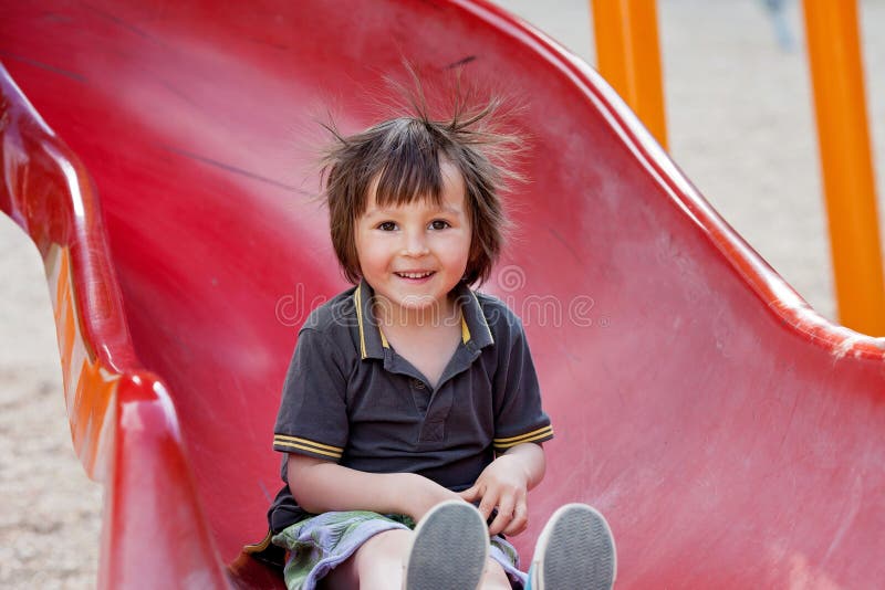 Adorable Little Boy, Going Down a Slide, Smiling at Camera Stock Image ...