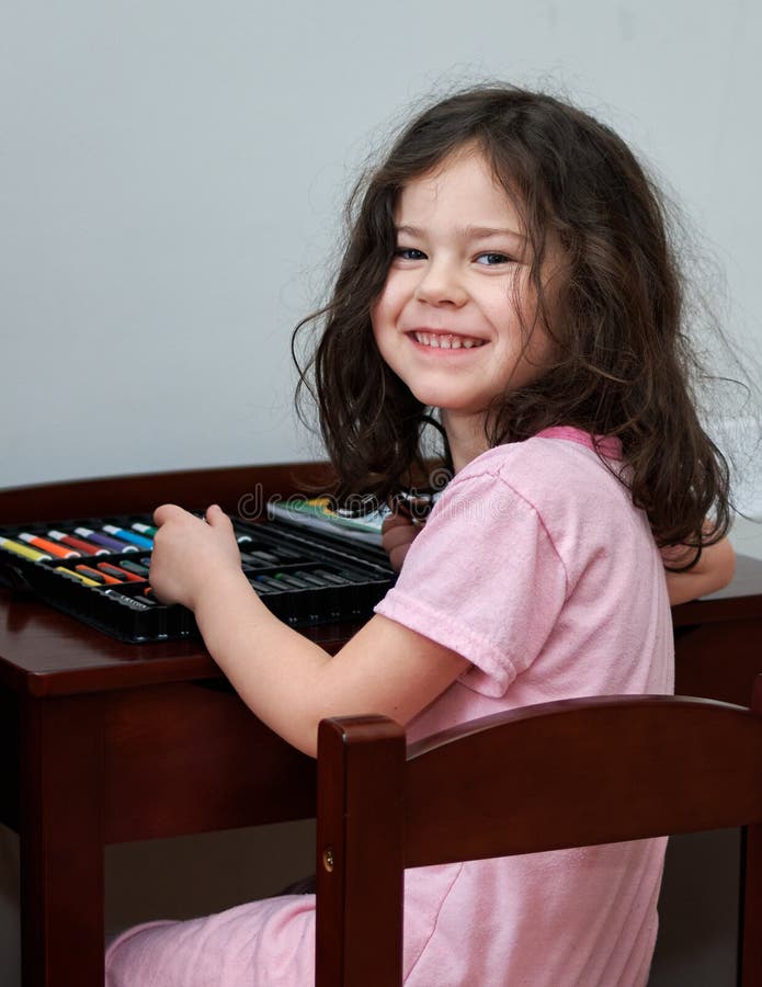 Adorable Little Girl Making Faces for the Camera while Sitting at a ...