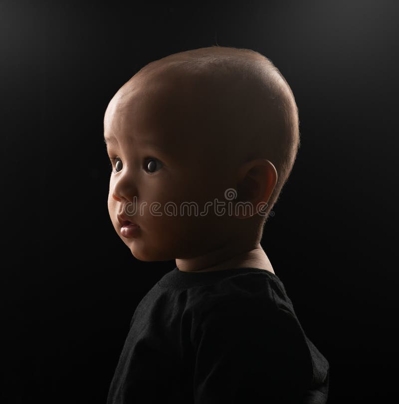 Adorable Profile of a Baby with a Shiny Bald Head in Dramatic Lighting ...