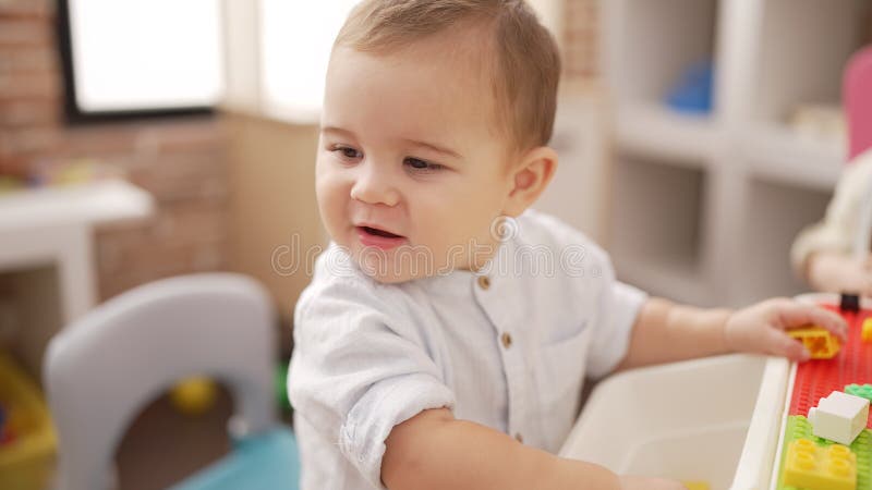 Adorable Toddler Holding Plastic Construction Blocks Sitting on Table ...
