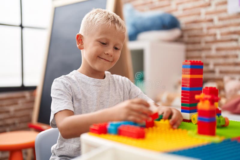 Adorable Toddler Playing with Construction Blocks Sitting on Table at ...