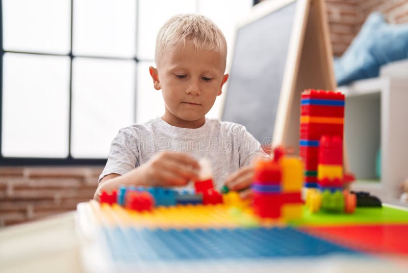 Adorable Toddler Playing with Construction Blocks Sitting on Table at ...