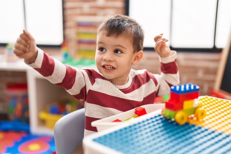 Adorable Toddler Playing with Construction Blocks Sitting on Table at ...