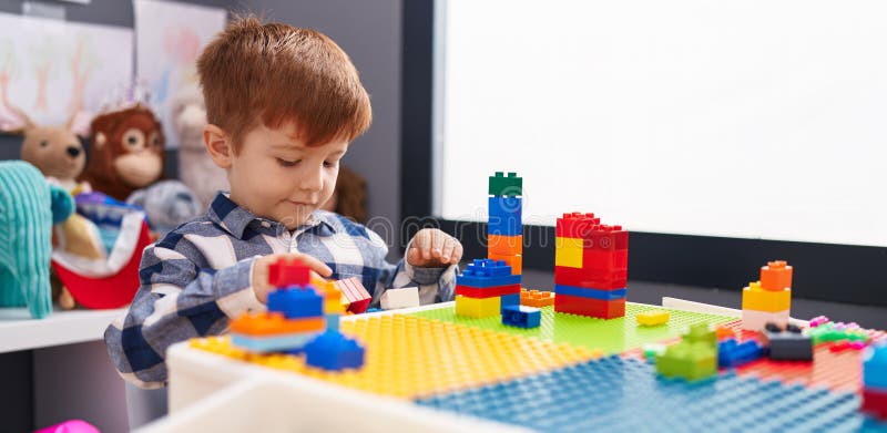 Adorable Toddler Playing with Construction Blocks Sitting on Table at ...