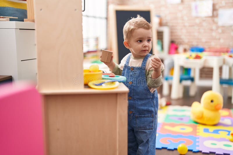 Adorable Toddler Playing with Play Kitchen Standing at Kindergarten ...