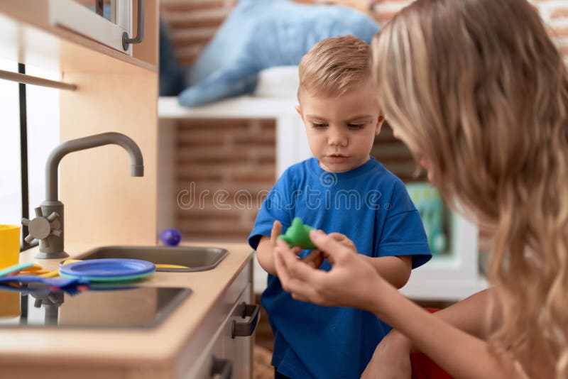 Adorable Toddler Playing with Play Kitchen Standing at Kindergarten ...