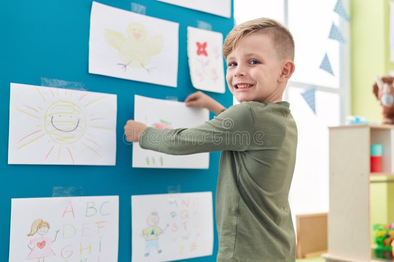 Adorable Toddler Smiling Confident Hanging Draw on Wall at Classroom ...