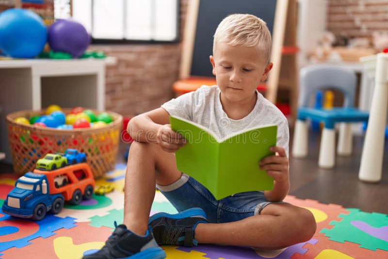 Adorable Toddler Student Reading Book Sitting on Floor at Classroom ...