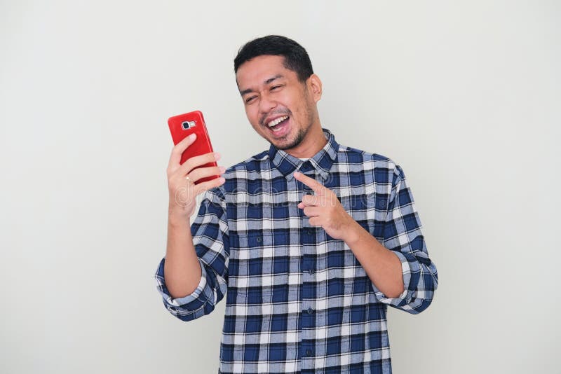 Adult Asian Man Laughing Happy When Looking To His Mobile Phone Stock