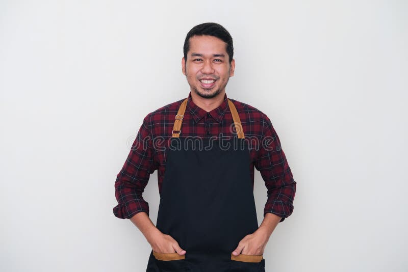 Adult Asian Man Wearing Apron Looking To The Camera And Smiling