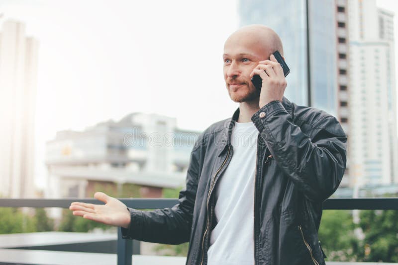 Adult Attractive Bald Bearded Man Talking by Mobile at City Street ... Adult Attractive Bald Bearded Man Talking by Mobile at City Street ...