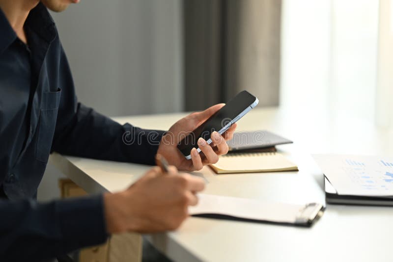 Adult Businessman Using Smartphone and Making Notes on Paper. People ...