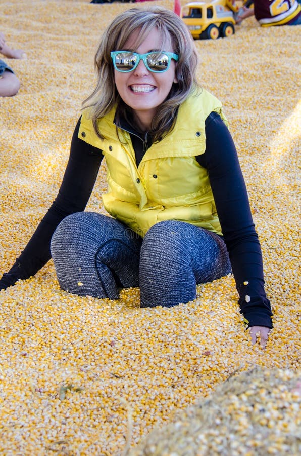 Adult Female Sits Down in a Corn Pit with Yellow Corn Kernels Stock ...