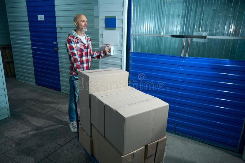 Adult Guy Opens a Storage Locker Roller Shutter Stock Photo - Image of ...