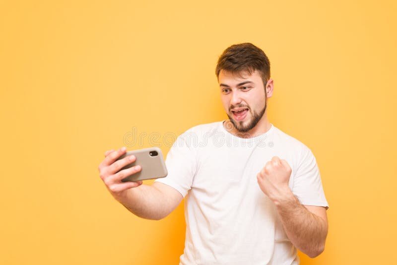 Adult Man With A Beard Playing Mobile Games On A Smartphone Looking At The Screen And Rejoicing 8556