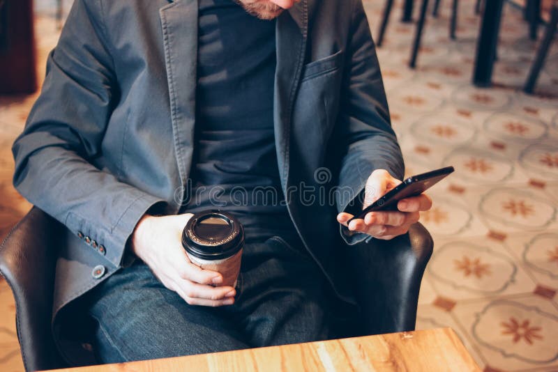 Adult Man Drinking Coffee from Paper Cup and Using Mobile Phone at Cafe ...