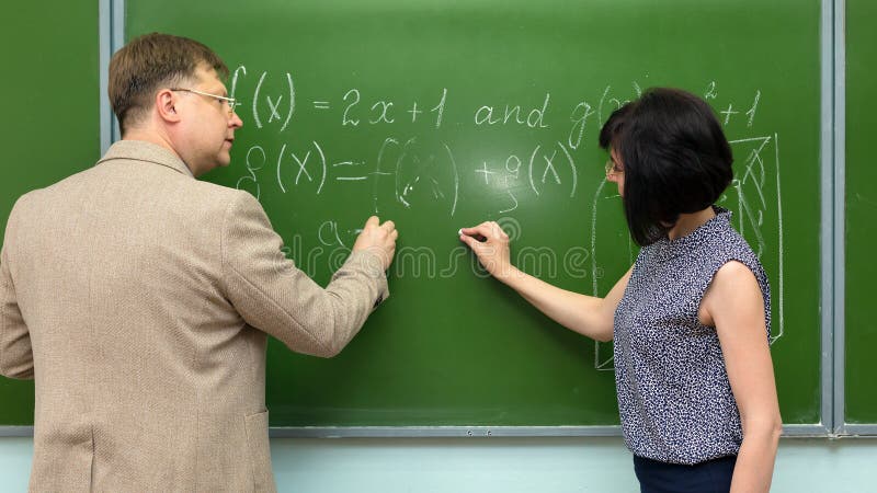 An Adult Teacher at the Blackboard Explains the Solution of a Math ...
