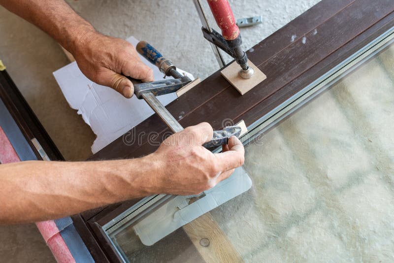 Man Holding C-clamp and Connect Elements of the Window Frame Stock ...