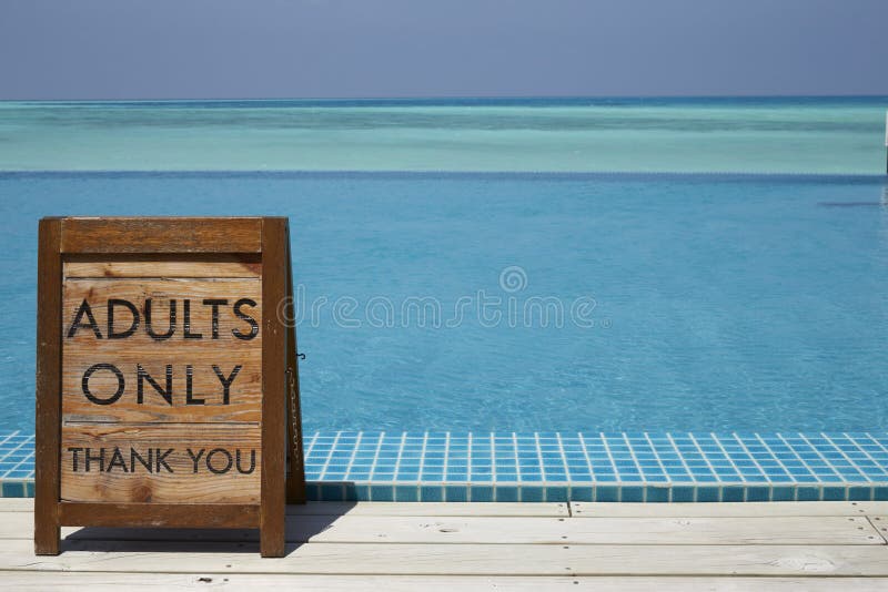 Adults only Sign by an Infinity Pool with Ocean Beyond Stock Photo ...