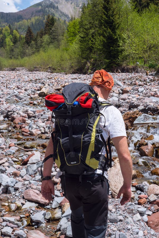Adventurer with Backpack Crosses a Mountain River Stock Photo - Image ...