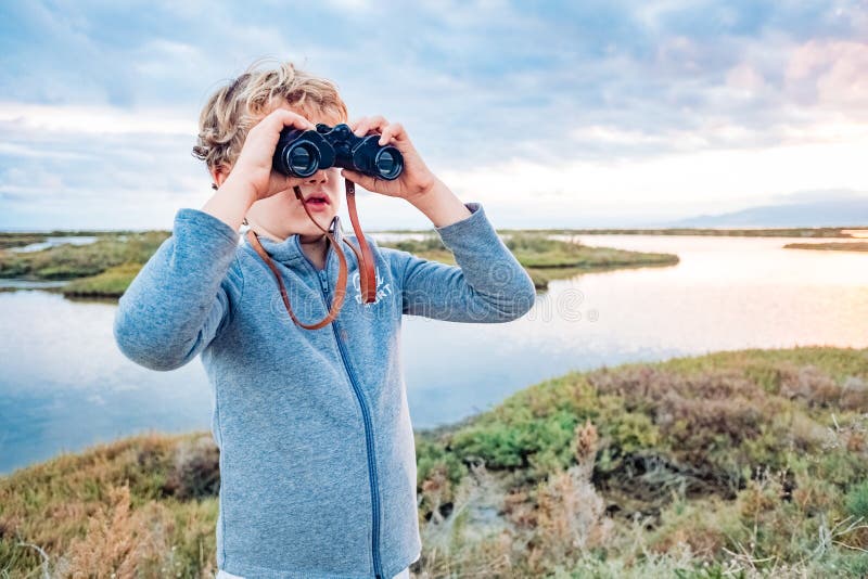 An Adventurous Boy Explores the Landscape with Binoculars with the ...