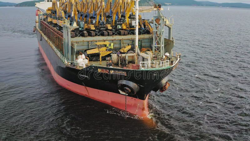 Aerial: Cargo Ship in Motion with Construction Equipment on Deck Stock ...