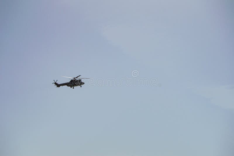 Aerial Distant Shot of a Helicopter Flying in the Blue Sky on a Sunny ...