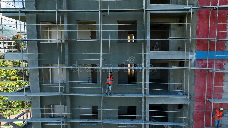 Builders Work Facing the Building Stand on the Scaffolding Stock ...