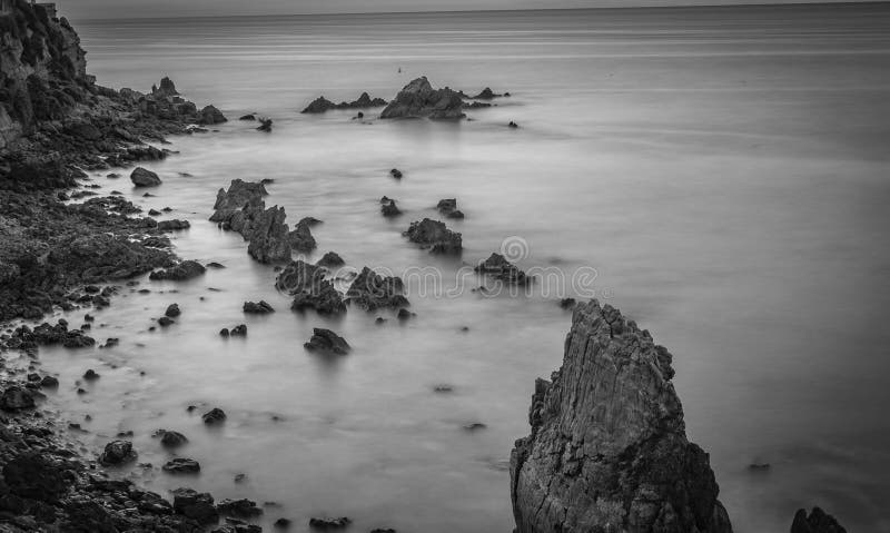 Aerial Grayscale of Pieces of Sharp Rocks in the Quiet Sea Stock Image ...