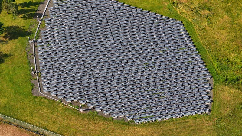 Aerial Shot of an Array of Solar Panels Set Up on a Grassy Meadow ...