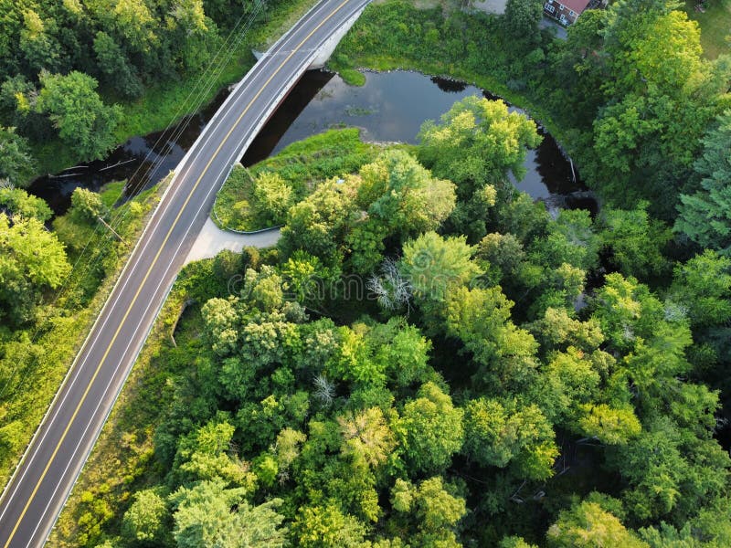 Aerial Shot of an Empty Road Over a Lake Surrounded by Trees Stock ...