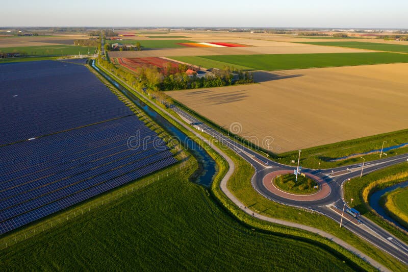 A Field of Solar Panels Gleaming in the Sunlight Surrounded by Green ...