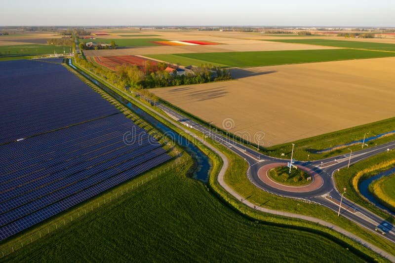 Aerial Shot of a Field of Solar Panels with a Round Road Intersection ...