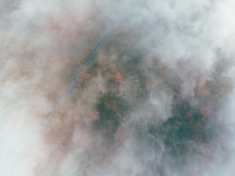 Aerial Top-down View through Clouds on Autumn Forest and Road Stock ...