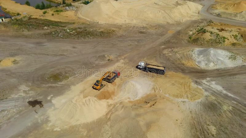 Aerial Top Down View of an Excavator Loading Crushed Sand into Truck in ...
