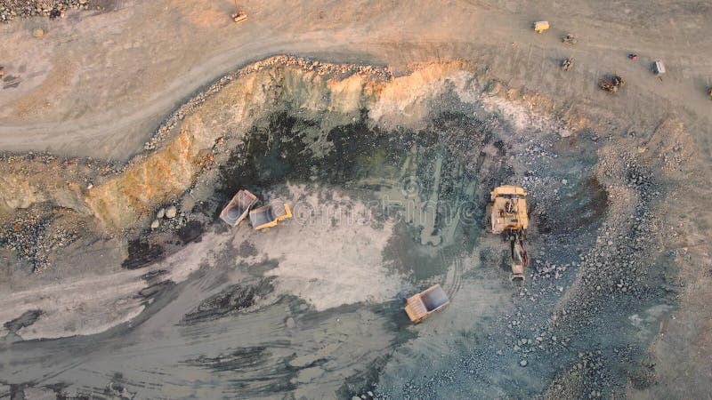 Aerial Top Down View of an Excavator Loading Crushed Stone into a Dump ...