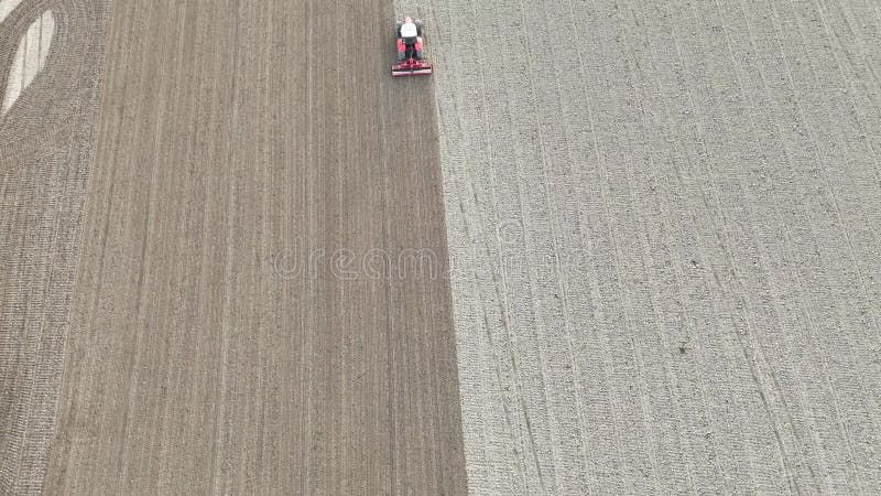 Red Tractor Plowing Dry Soil Field with Precision Rows Visible from Top ...