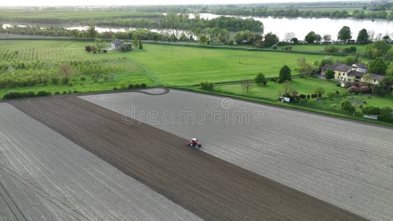 Red Tractor Plowing Dry Soil Field with Precision Rows Visible from Top ...