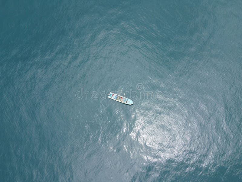 Aerial Top View of a Boat Floating on a Pristine Blue Body of Water ...