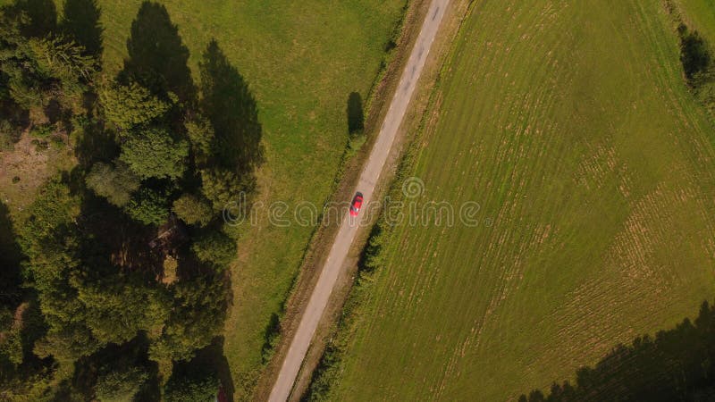 Aerial Top View of a Single Red Car Driving on a Highway Surrounded by ...