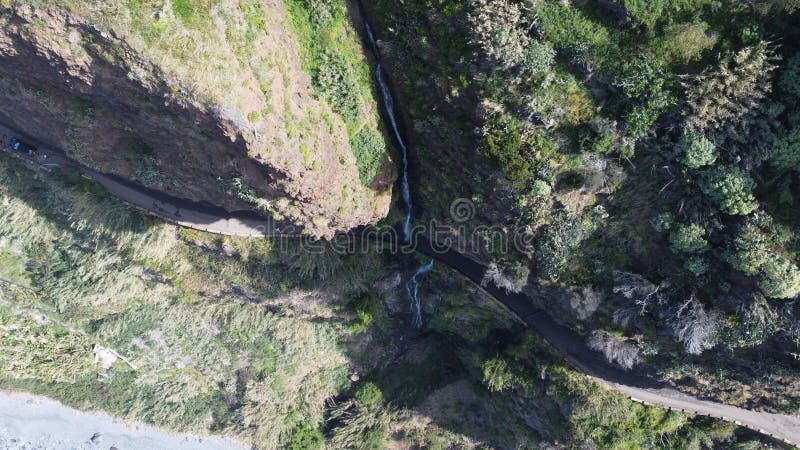 Aerial Top View of a Waterfall Flowing Down the Rocks Covered with ...