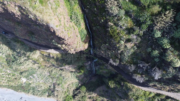 Aerial Top View of a Waterfall Flowing Down the Rocks Covered with ...