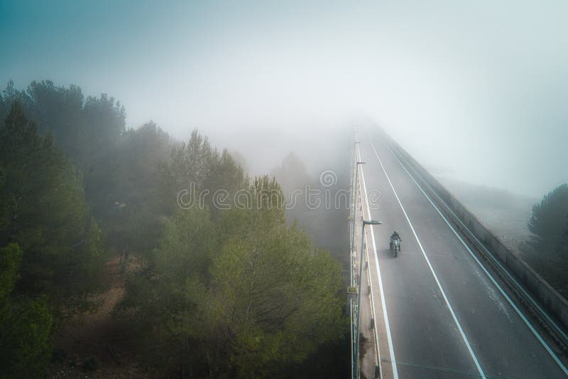 Aerial View of a Biker Crossing a Bridge Covered with Fog Stock Photo ...